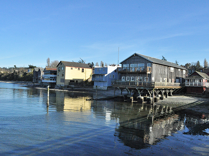 Waterfront homes reflect in the glassy morning waters, their stilts and pilings creating a scene straight from a Pacific Northwest fairy tale.