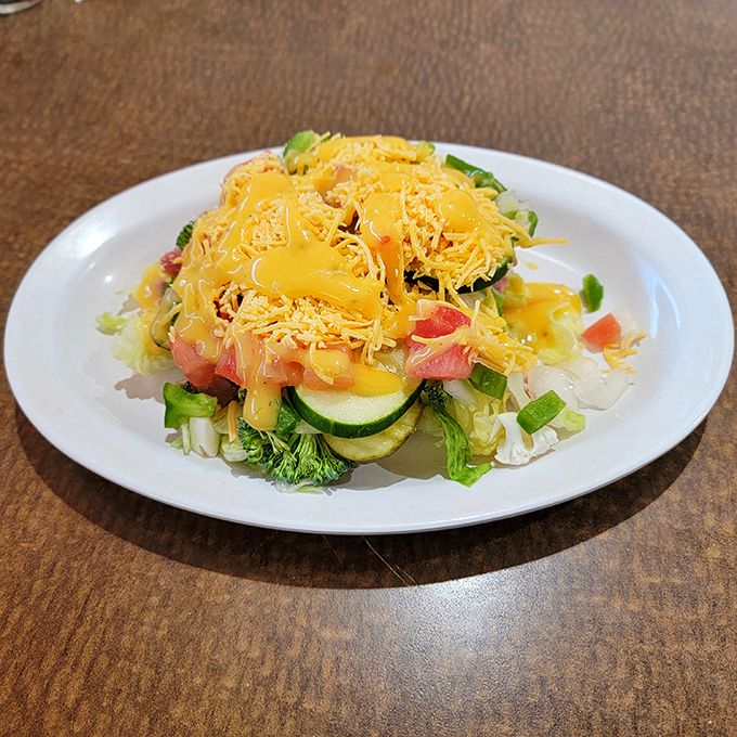 Garden-fresh ingredients topped with generous cheese—proof that sometimes salads aren't just what food eats before becoming food.