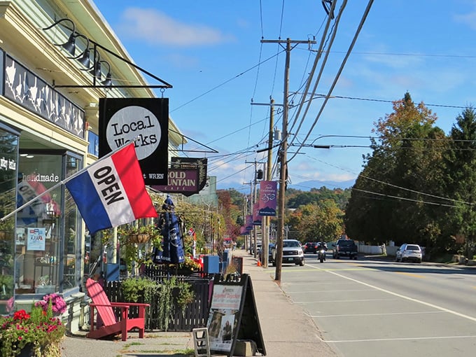 Sidewalk culture, mountain-town style. Local Works' open flag waves hello while White Mountains stand guard in the distance.