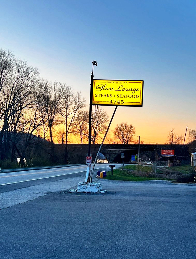 The roadside sign glows against the twilight sky, a beacon of hope for hungry travelers and locals alike.