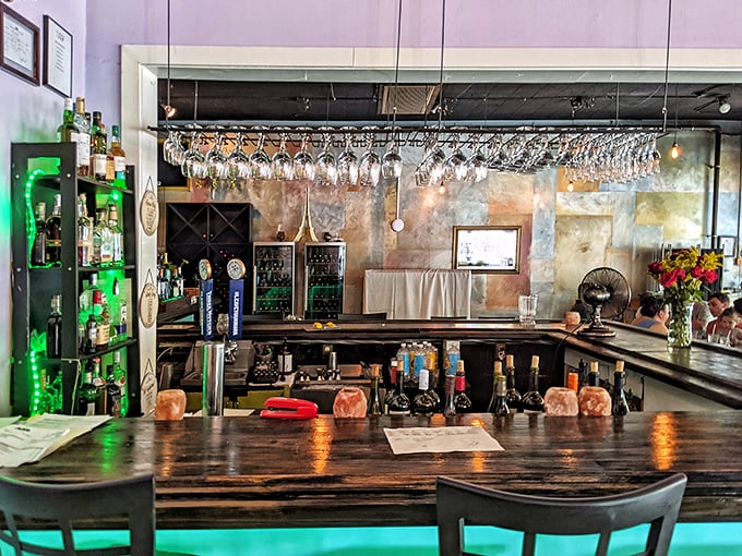 The bar's soft blue glow and hanging glassware create the perfect backdrop for that "I deserve this" glass of wine after conquering your Wednesday.