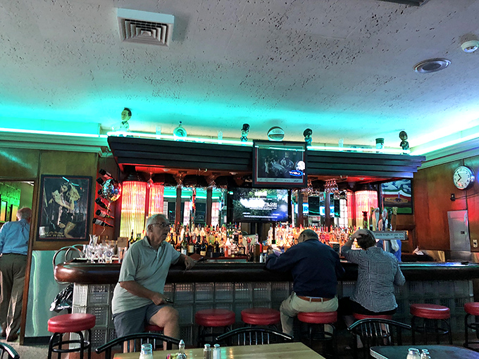 The bar glows with an otherworldly blue light, bottles standing at attention, ready to pour liquid courage for those tackling the full lasagna portion.