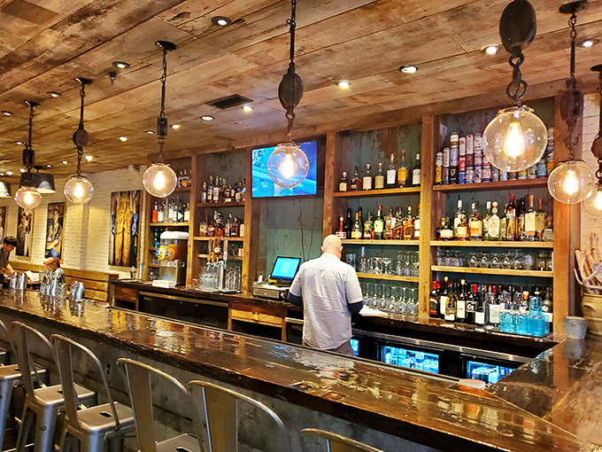 Behind the bar, bottles stand at attention like sailors, ready to craft the perfect companion beverage for your seafood adventure.