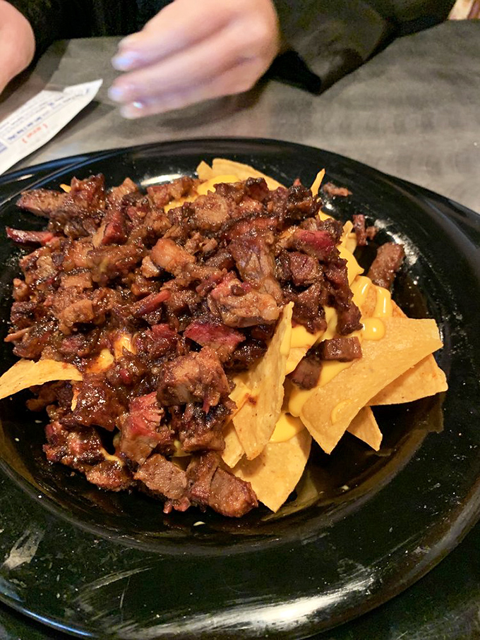Brisket nachos: where Texas tradition meets game day indulgence. The hand reaching in speaks for all of us.
