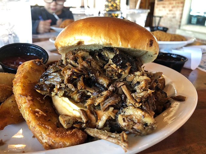 A pulled pork sandwich so generous it requires strategic planning just to take the first bite—the Mount Everest of lunch options.