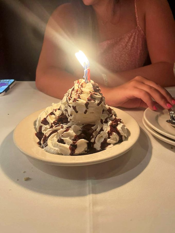 A mountain of brownie and ice cream with a birthday candle on top &ndash; because some celebrations require structural engineering and chocolate.