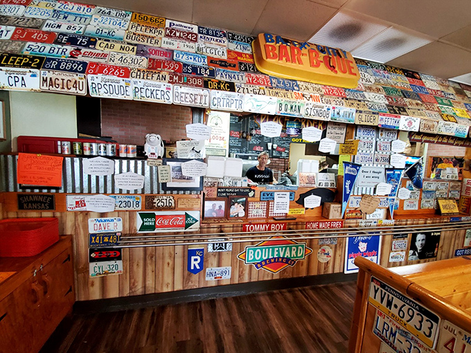 The counter where barbecue dreams come true, topped with enough license plates to start a small DMV office.