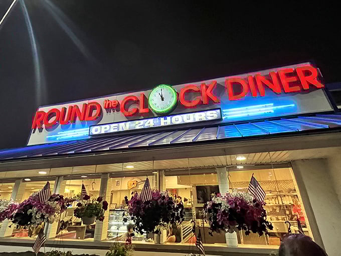 As twilight falls, the neon sign becomes a lighthouse for hungry travelers. Those hanging flower baskets add a touch of unexpected beauty. 