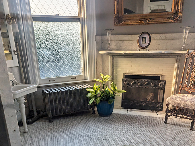 This elegant fireplace anchors a room where the past feels particularly present. The marble mantel has outlasted generations of both residents and visitors.
