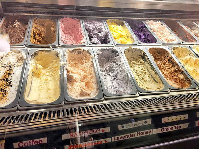 The display case reveals a United Nations of ice cream flavors, each pan awaiting its diplomatic mission to your taste buds.