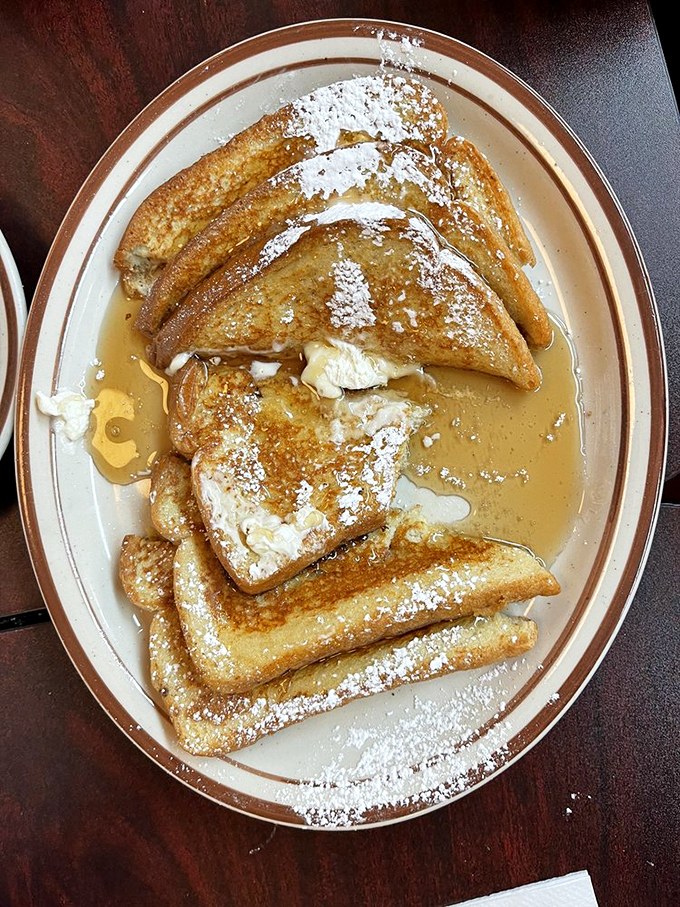 French toast that's crossed the line from breakfast to dessert, swimming in maple syrup and dusted with powdered sugar snowfall.