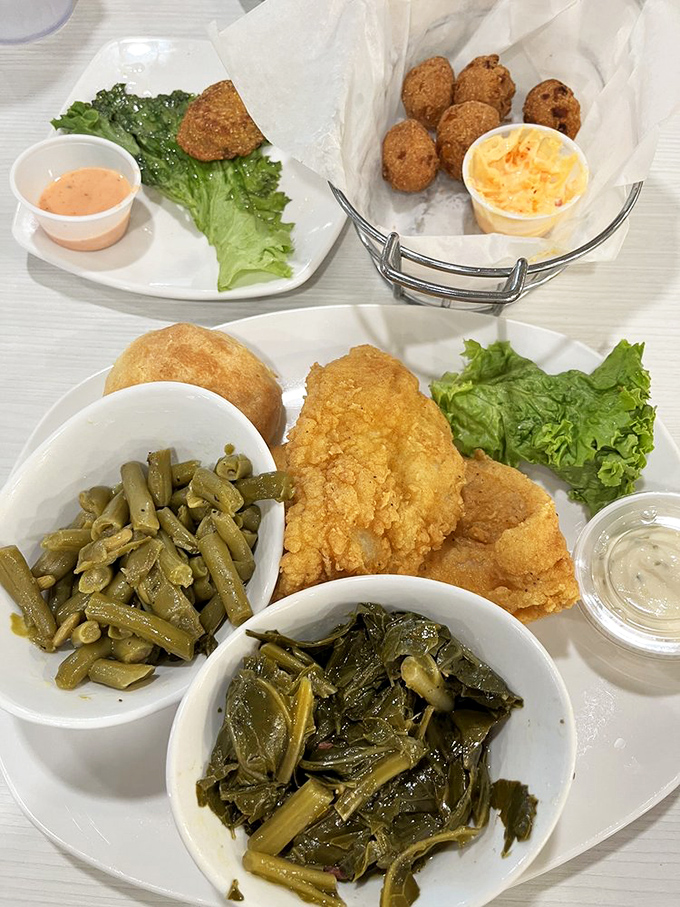 Southern feast in full glory: crispy fried catfish, slow-cooked collards, green beans, and a golden roll. Diet plans, beware.