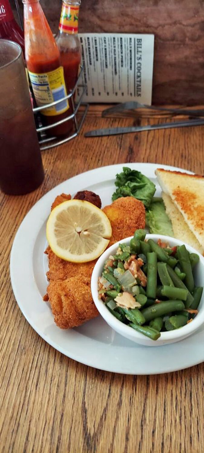 Crispy catfish with a cornmeal crust that crackles with each bite, served with green beans that actually taste like vegetables should. This is Oklahoma comfort on a plate.