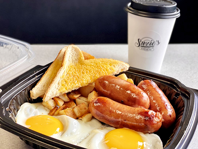 The breakfast trinity: golden-yolked eggs, maple-kissed sausage links, and perfectly browned toast. Simple perfection on a plate.