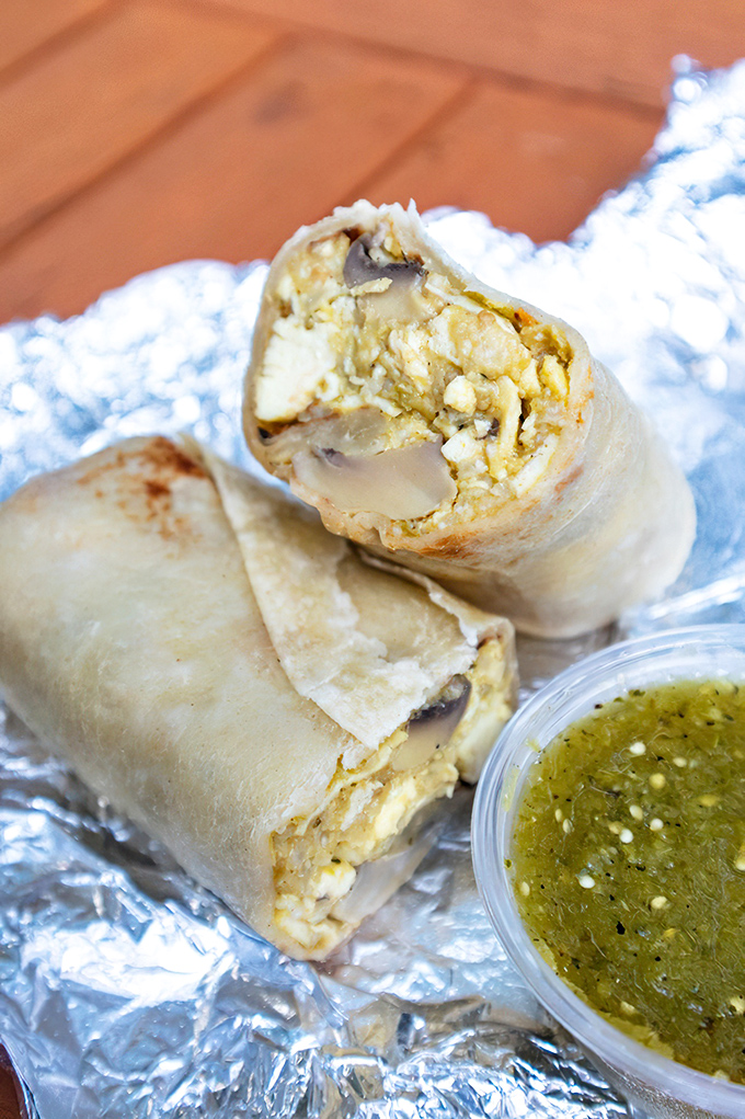 Golden eggs meet their perfect companions inside a handcrafted tortilla. The filling's texture suggests someone in the kitchen understands what breakfast should be.