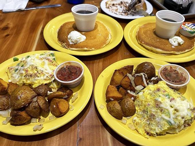 Four bright yellow plates of breakfast bounty that prove the best family-style dining happens when everyone orders something different and shares.