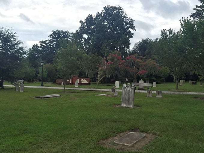 Flat grave markers dot the immaculate lawn like stepping stones through history, each one a chapter in Savannah's fascinating story.
