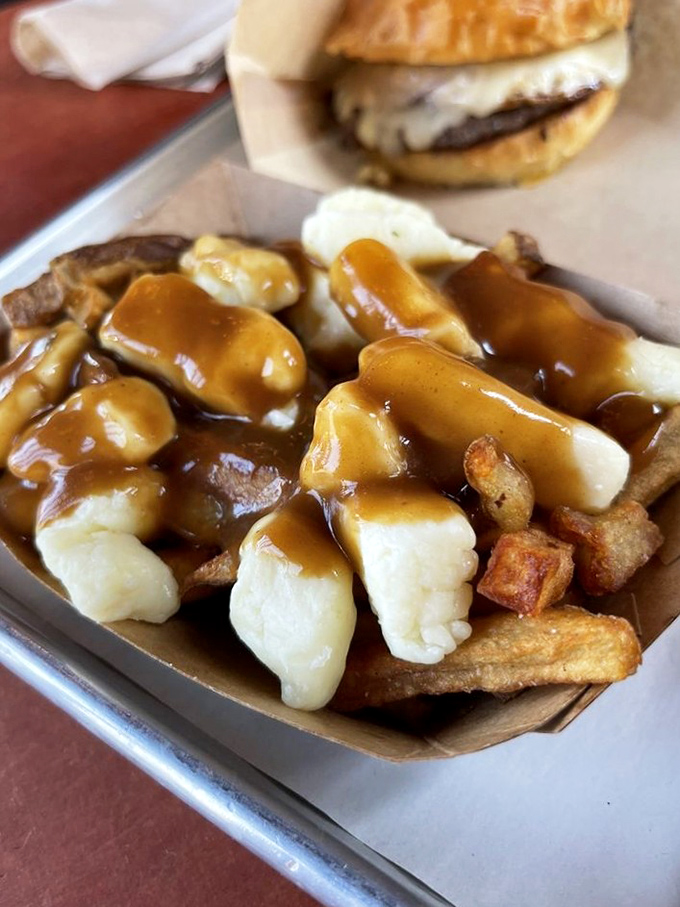 Cheese curds melting into golden fries under a blanket of rich gravy. This isn't just poutine&mdash;it's comfort in a cardboard container.