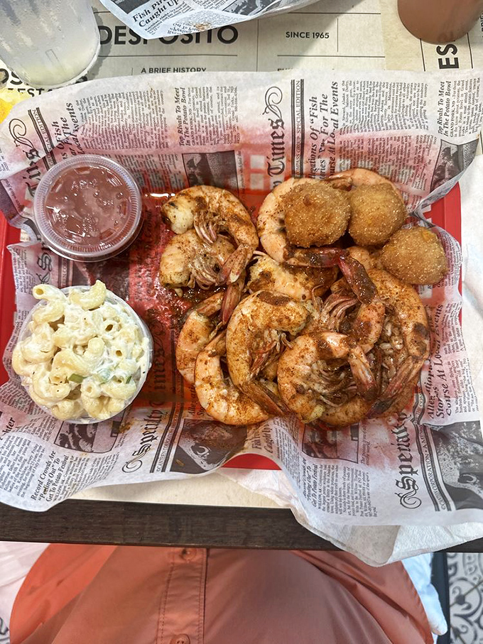 The holy trinity of Southern coastal dining: perfectly fried shrimp, creamy macaroni salad, and hush puppies that would make your grandma jealous.