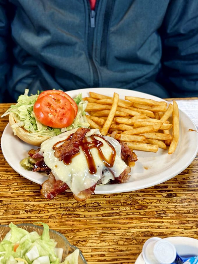 This burger isn't just wearing cheese and bacon&mdash;it's strutting them like a fashion statement. Fries standing by as loyal sidekicks.