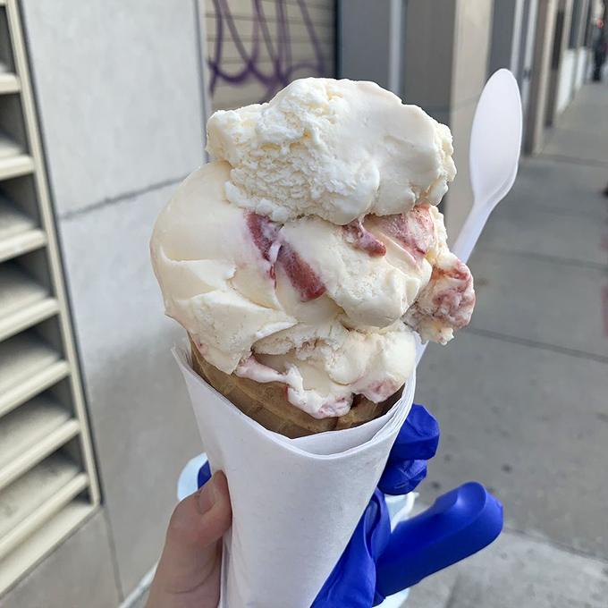 This cone isn't just street food - it's a portable masterpiece of strawberry cheesecake ice cream that makes walking and eating an art form.