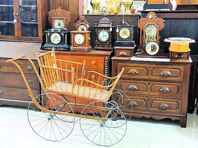 A parade of antique clocks and a wicker baby carriage that would make any vintage enthusiast's heart tick faster than those timepieces.