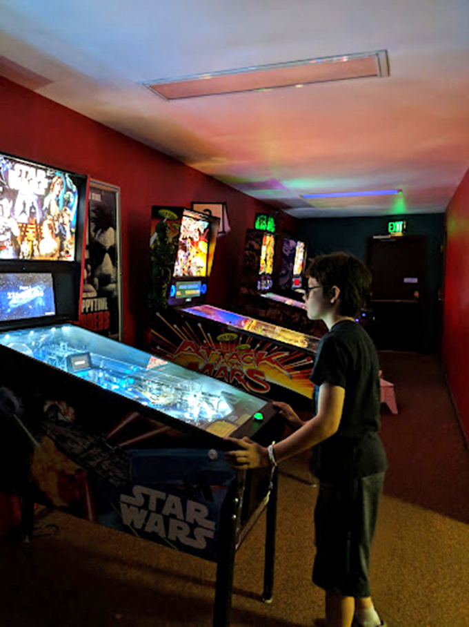 While waiting for showtime, young gamers test their skills on vintage pinball machines, creating preludes to the feature presentation.