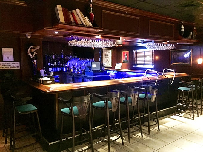 A bar that whispers "come sit awhile" with its warm wood tones and blue accent lighting—perfect for pre-dinner martinis.