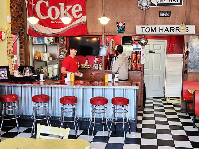 The counter where magic happens, complete with classic red stools and Coca-Cola memorabilia. Some bars serve spirits; this one serves happiness.