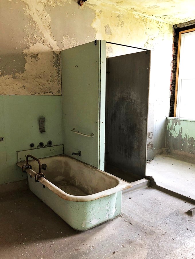 A mint-green bathtub and shower stall remain, making you wonder if the water ever truly ran warm in this cold, unforgiving place. 