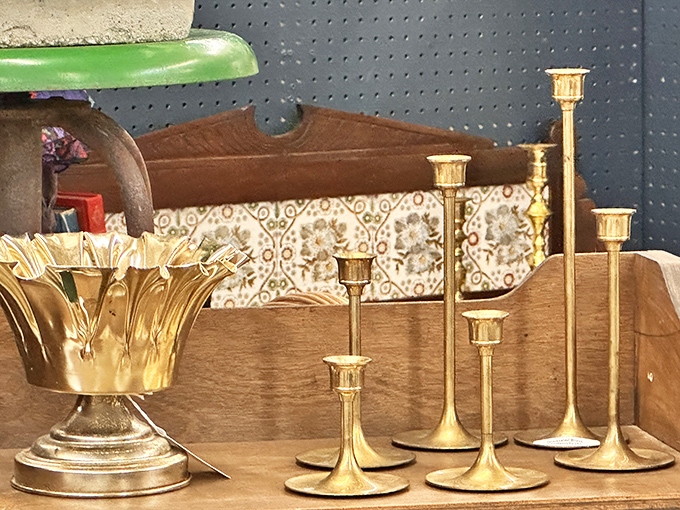 Brass candlesticks in graduated heights stand like a family portrait. Before electricity, these were both necessity and luxury in American homes.