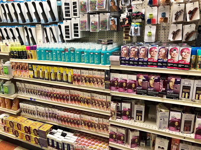 Beauty products line up like soldiers in a discount army, fighting the good fight against overpriced personal care. The colorful hair dyes practically sing with possibility.