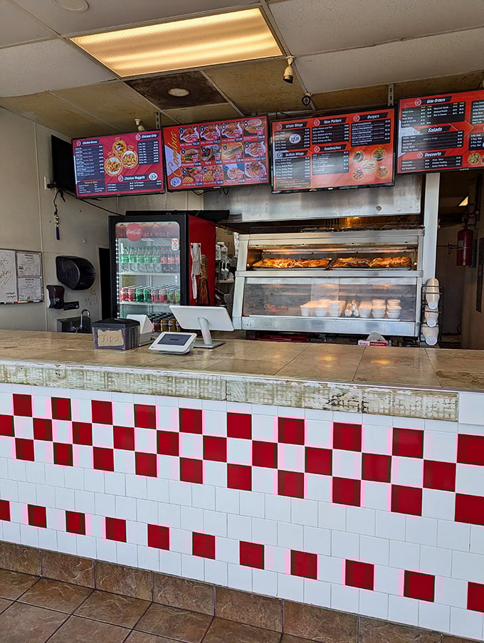 The menu boards loom above like billboards advertising happiness, while the warming trays below promise immediate satisfaction.