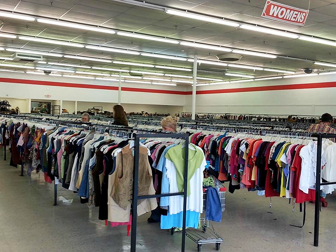 The women's section buzzes with quiet concentration as shoppers scan for hidden gems among the color-coded racks.