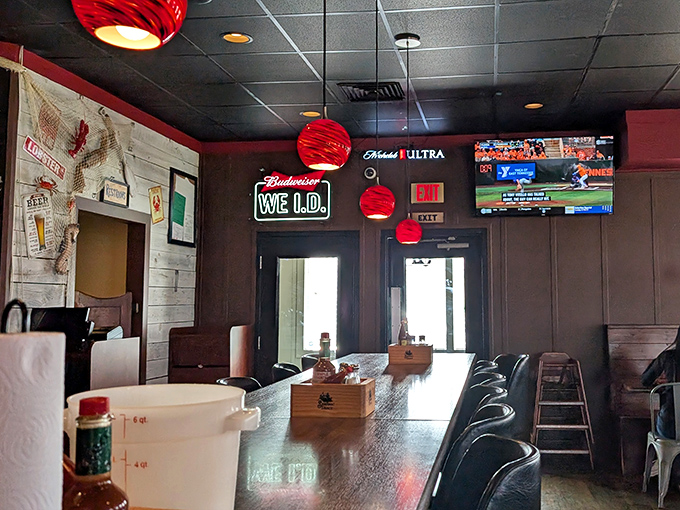 Red pendant lights cast a warm glow over wood-paneled walls. Even the "We I.D." sign looks like it belongs on a particularly law-abiding pirate ship.