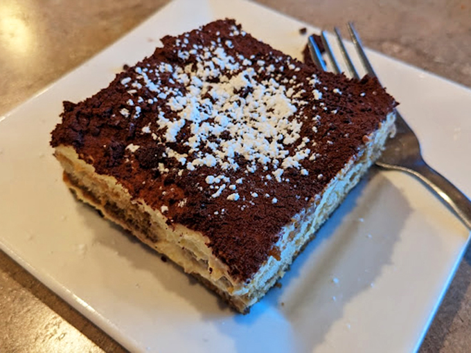 Tiramisu that strikes the perfect balance between cake and cream. The powdered sugar isn't decoration—it's the final brushstroke on an edible masterpiece.