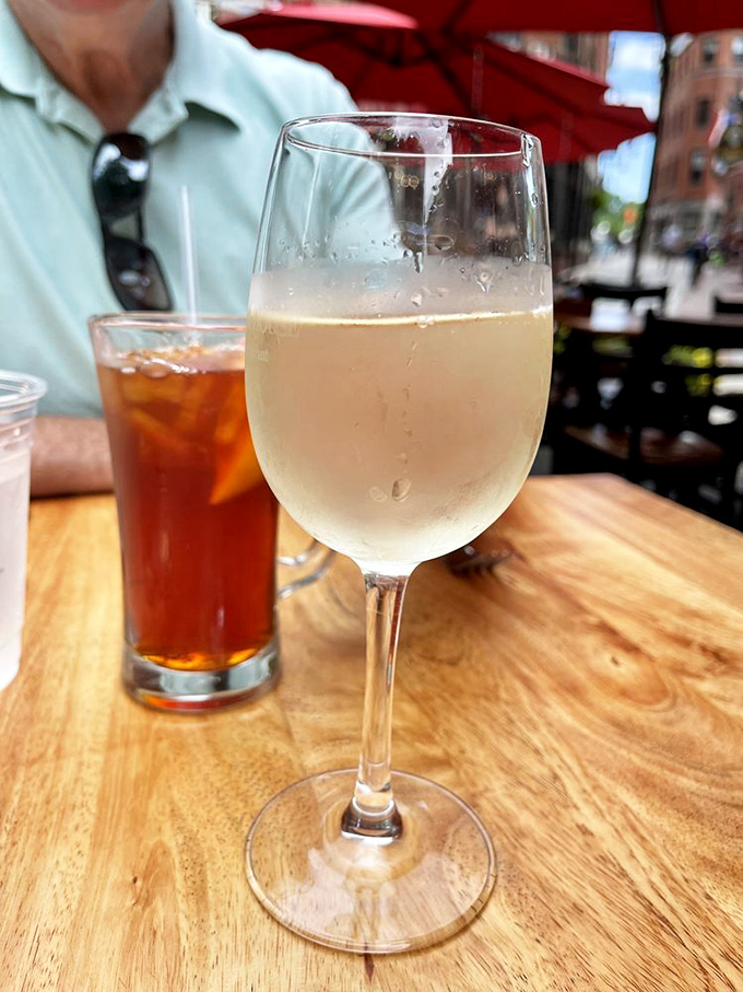 Wine and iced tea on a weathered wooden table &ndash; civilization's perfect companions for an afternoon exploring Boston's culinary history.