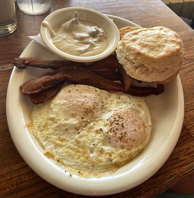 The platonic ideal of breakfast&mdash;a perfectly fried egg, bacon with architectural integrity, and a biscuit that would make your grandmother both proud and jealous.