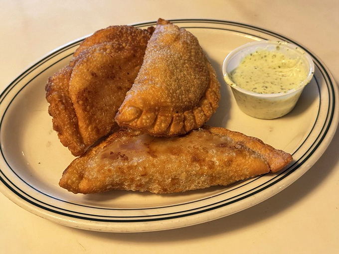 Golden-fried empanadas with their perfectly crimped edges stand ready to reveal their savory secrets. Resistance is futile.