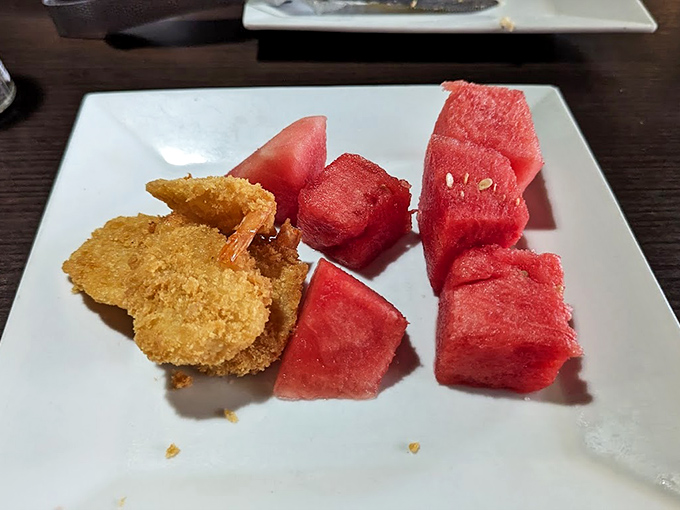 A plate that understands balance: golden-fried shrimp for indulgence, fresh watermelon for virtue. It's the yin and yang of dining satisfaction.