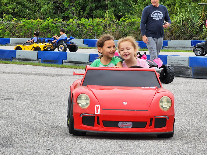 Double the smiles, double the fun. These young racers in their mini Porsche are experiencing the joy that comes before a lifetime of speeding tickets.