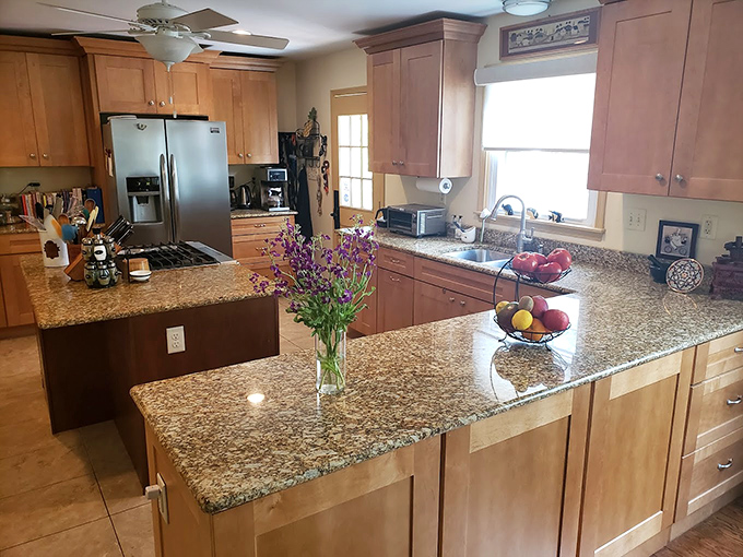 A kitchen that manages to be both functional and photogenic, with granite countertops that have never known the shame of microwave pizza.