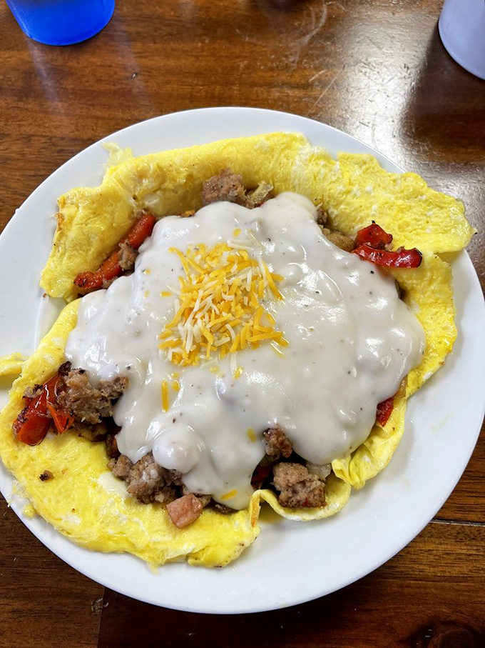 This isn't just an omelet; it's a masterpiece with gravy. The cheese on top is melting into breakfast nirvana.