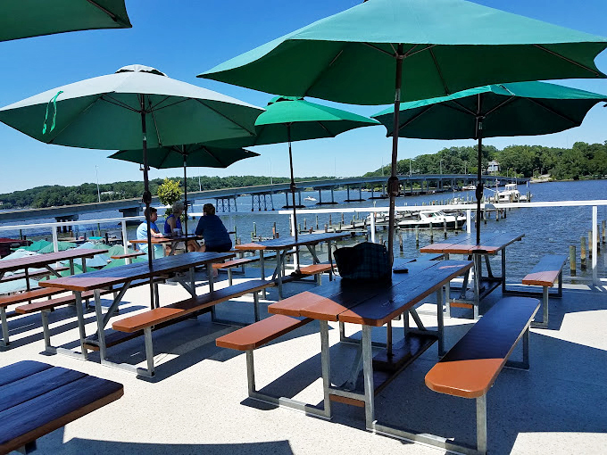 Sun-drenched outdoor seating where turquoise umbrellas stand guard against the only thing that could interrupt your crab feast—sunburn.