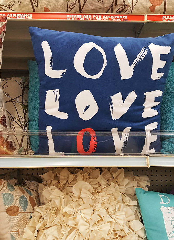 A pillow that doesn't just say "LOVE"&mdash;it shouts it three times, because subtle home d&eacute;cor is so last season.
