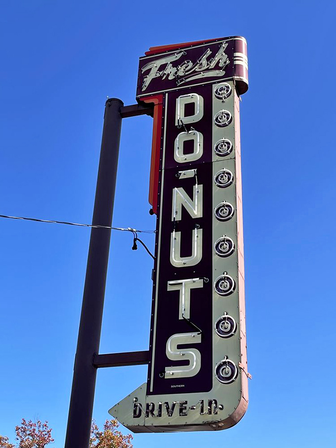 That vintage neon sign has been guiding hungry travelers for generations. Like a lighthouse, but for people craving fried dough instead of safe harbor.