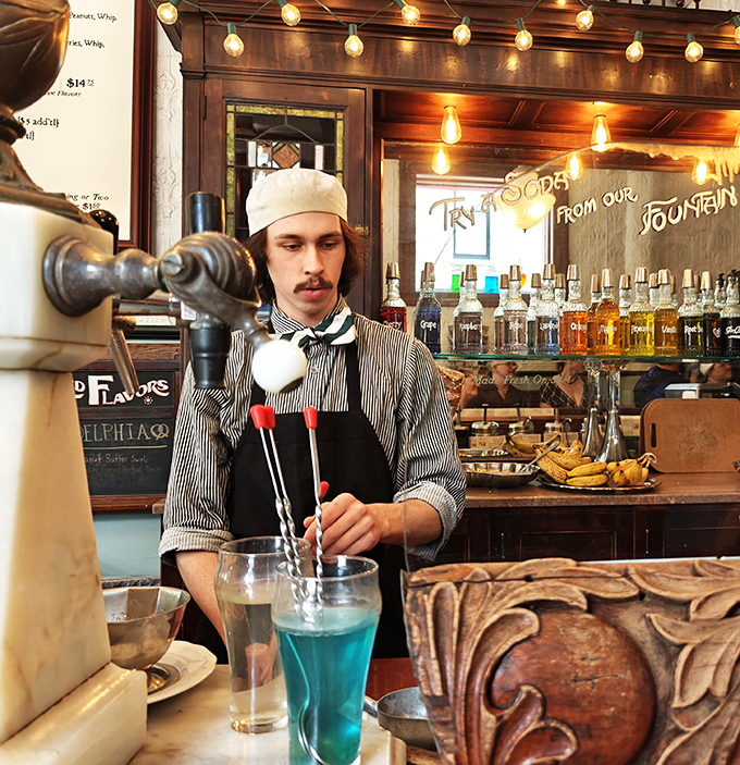 This isn't just a soda jerk&mdash;he's an artist in period-appropriate attire, crafting blue elixirs that would make Willy Wonka jealous. 
