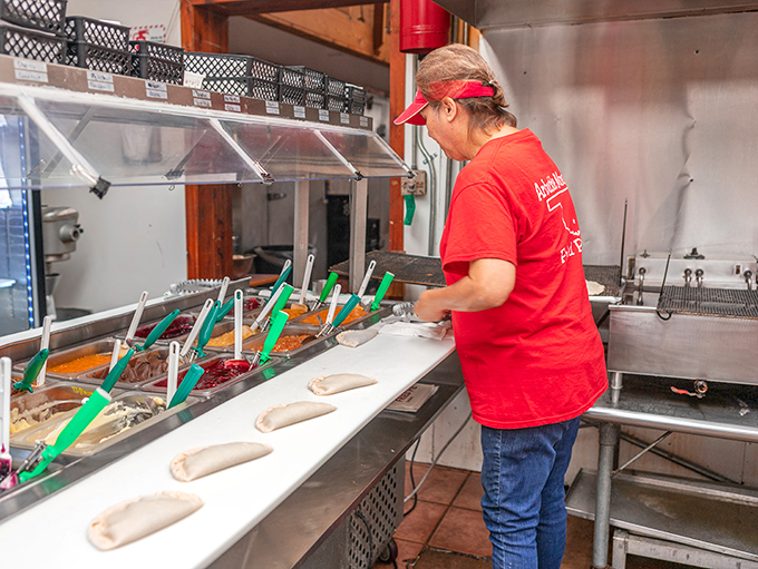 The assembly line of deliciousness. Each pie gets the personal touch&mdash;a culinary choreography perfected over countless crusts.