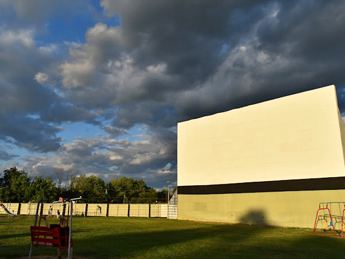 The golden hour glow bathes moviegoers in magic as they prepare for that perfect moment when daylight fades and the screen illuminates.