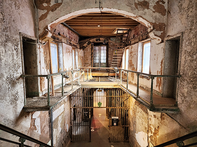 Sunlight streams through skylights that once represented inmates' only connection to the outside world. Nature always finds a way in.